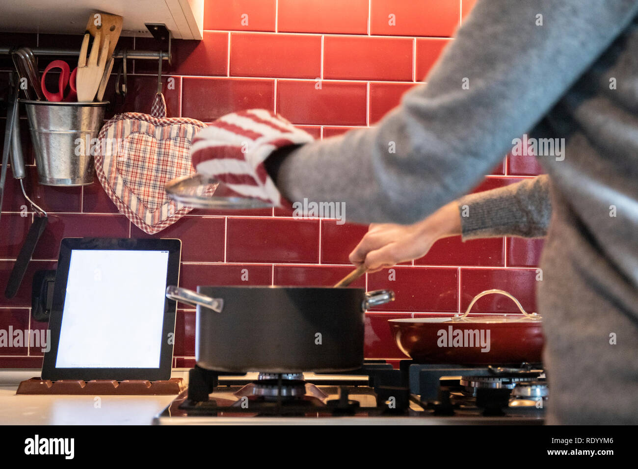 Woman cooking on gas stove in her kitchen hi-res stock photography and ...