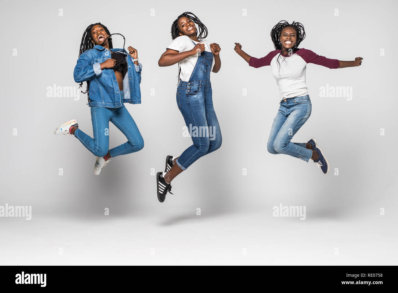 Three different women afro american jumping with happiness,on white ...