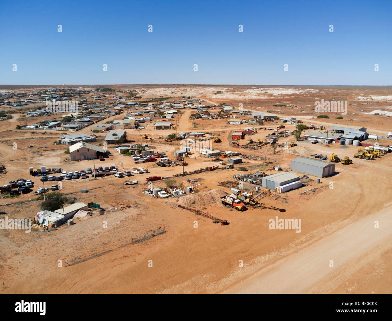 Aerial view of a small, remote desert town with buildings and vehicles ...