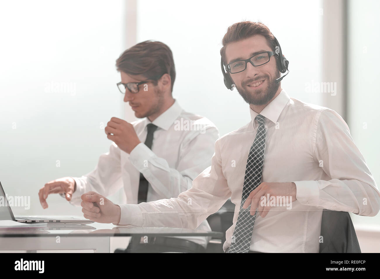 Manager with the headset works in a modern office Stock Photo - Alamy