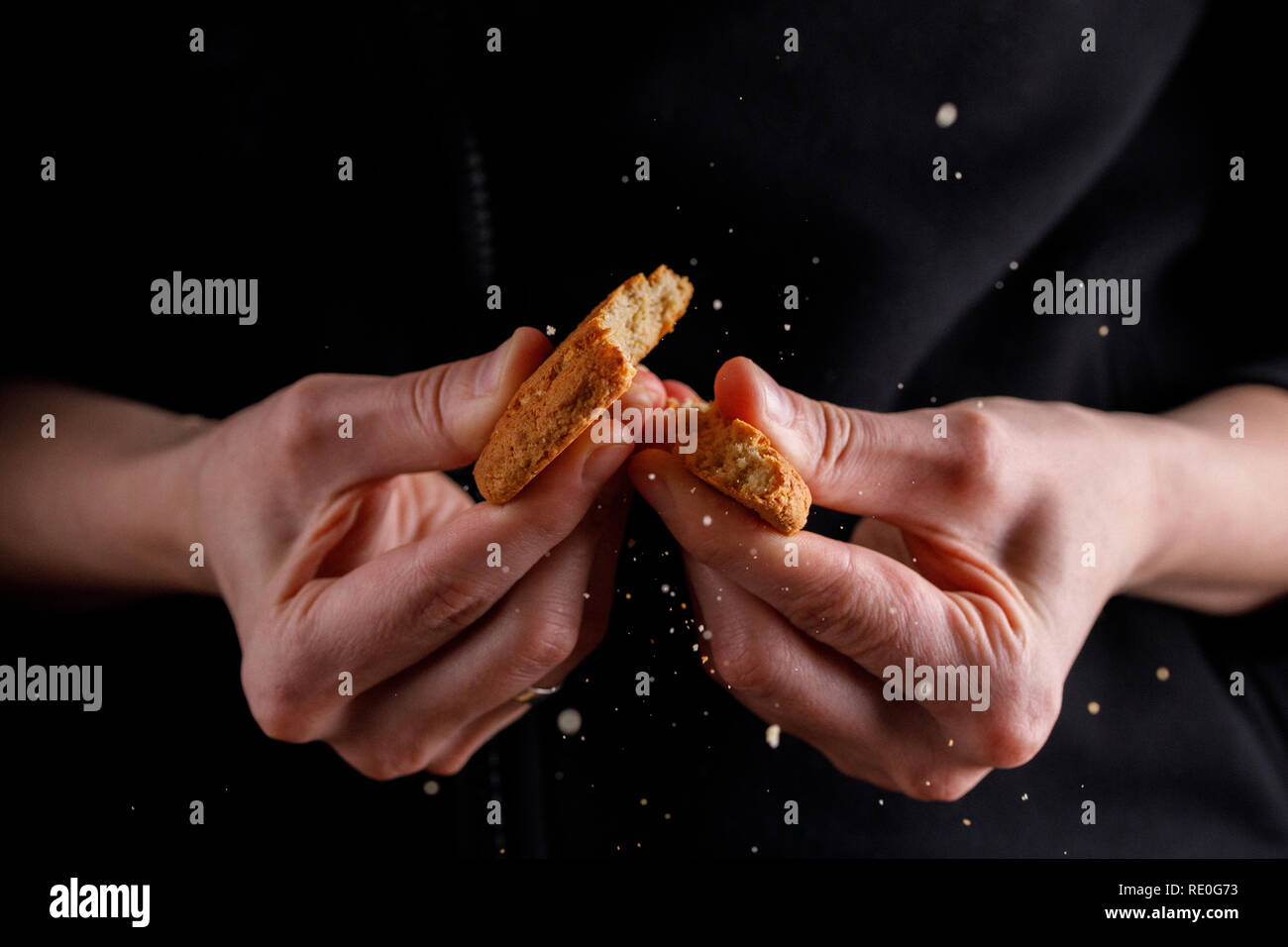Cookies breaking in the hands on a dark background. Macro Stock Photo ...