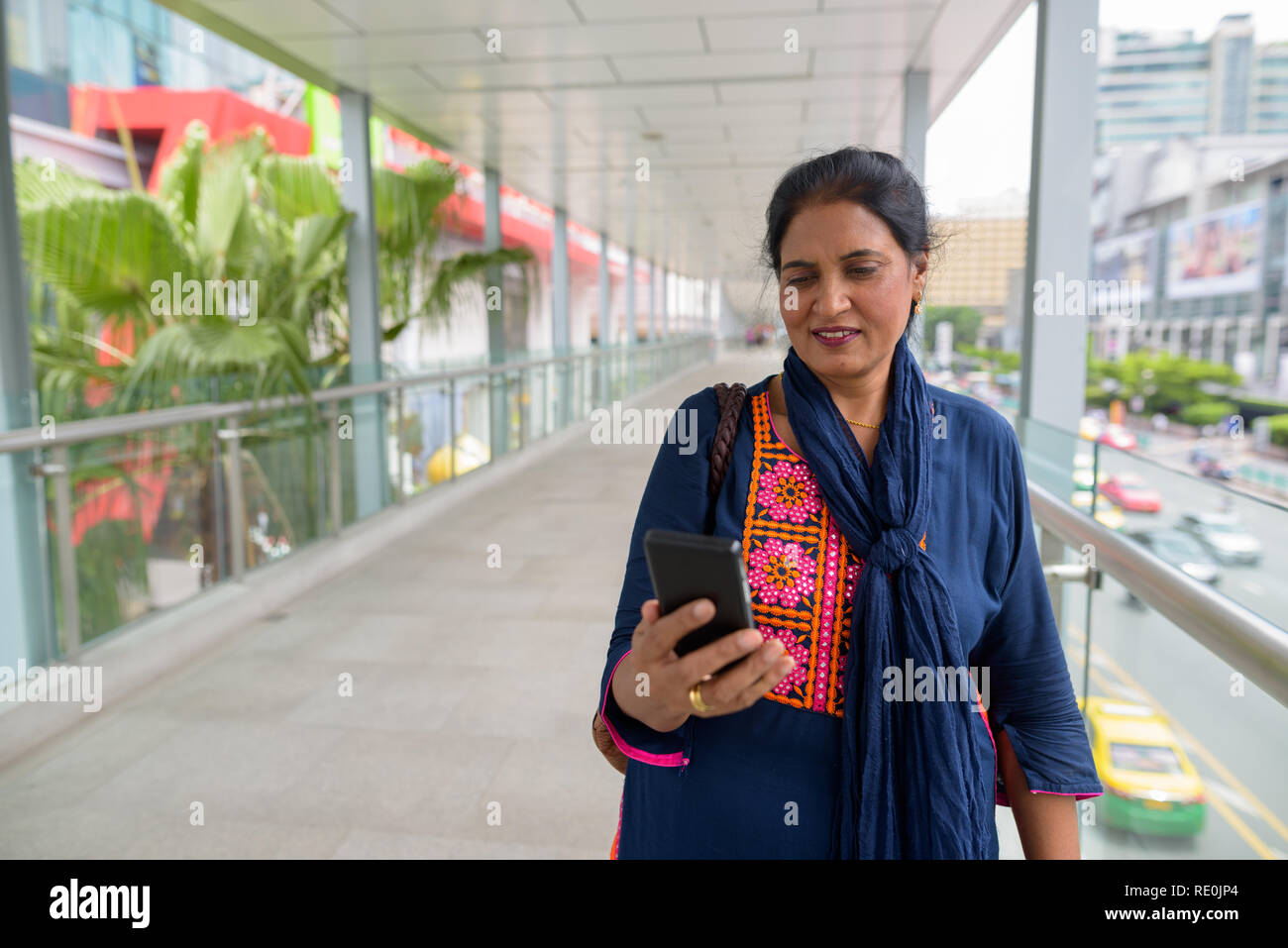 Mature beautiful Indian woman using digital tablet Stock Photo - Alamy