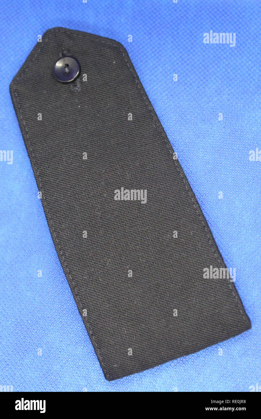 Fire service black epaulette on blue background Stock Photo - Alamy