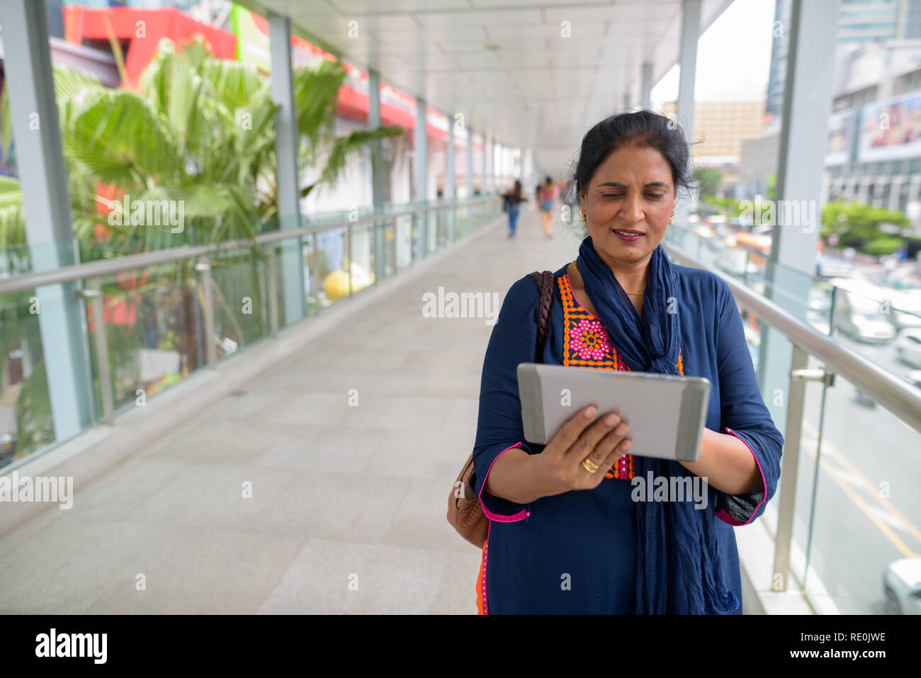 Mature beautiful Indian woman using digital tablet Stock Photo - Alamy