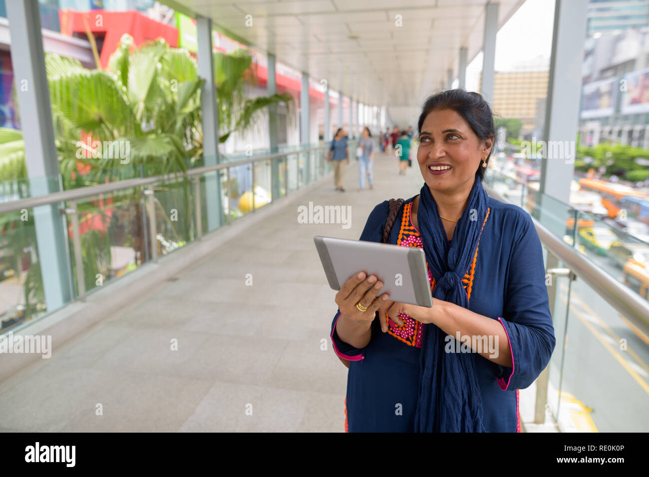 Mature beautiful Indian woman using digital tablet Stock Photo - Alamy