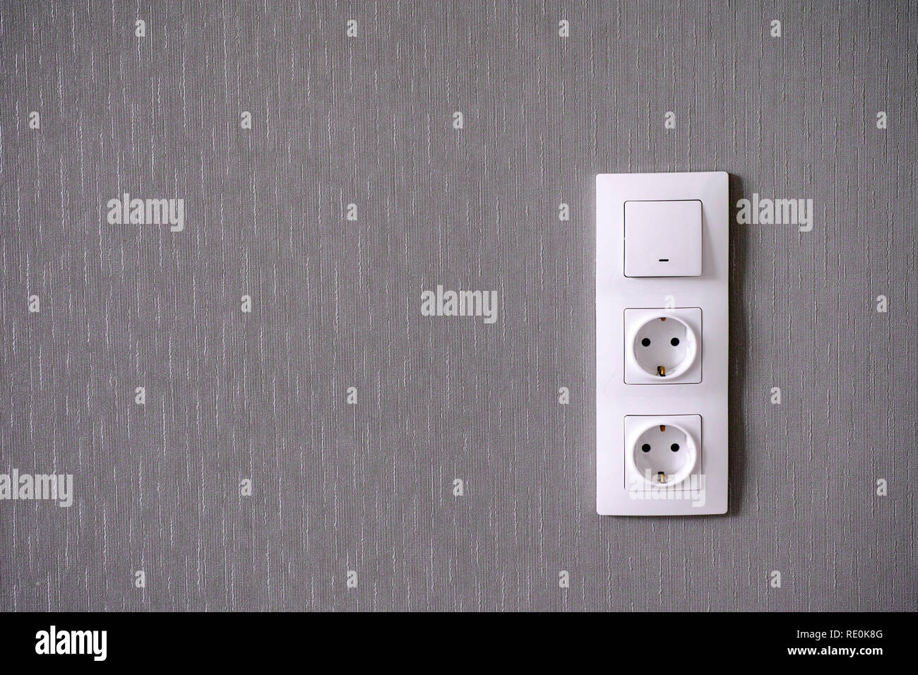 Two power sockets and Light switch on gray wall. Close-up Stock Photo ...