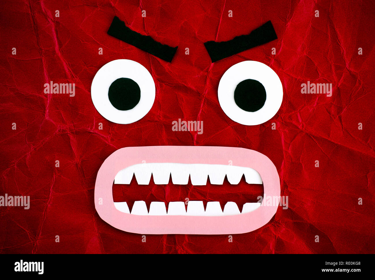 Angry emotional face made from paper. Red background. Close-up Stock ...
