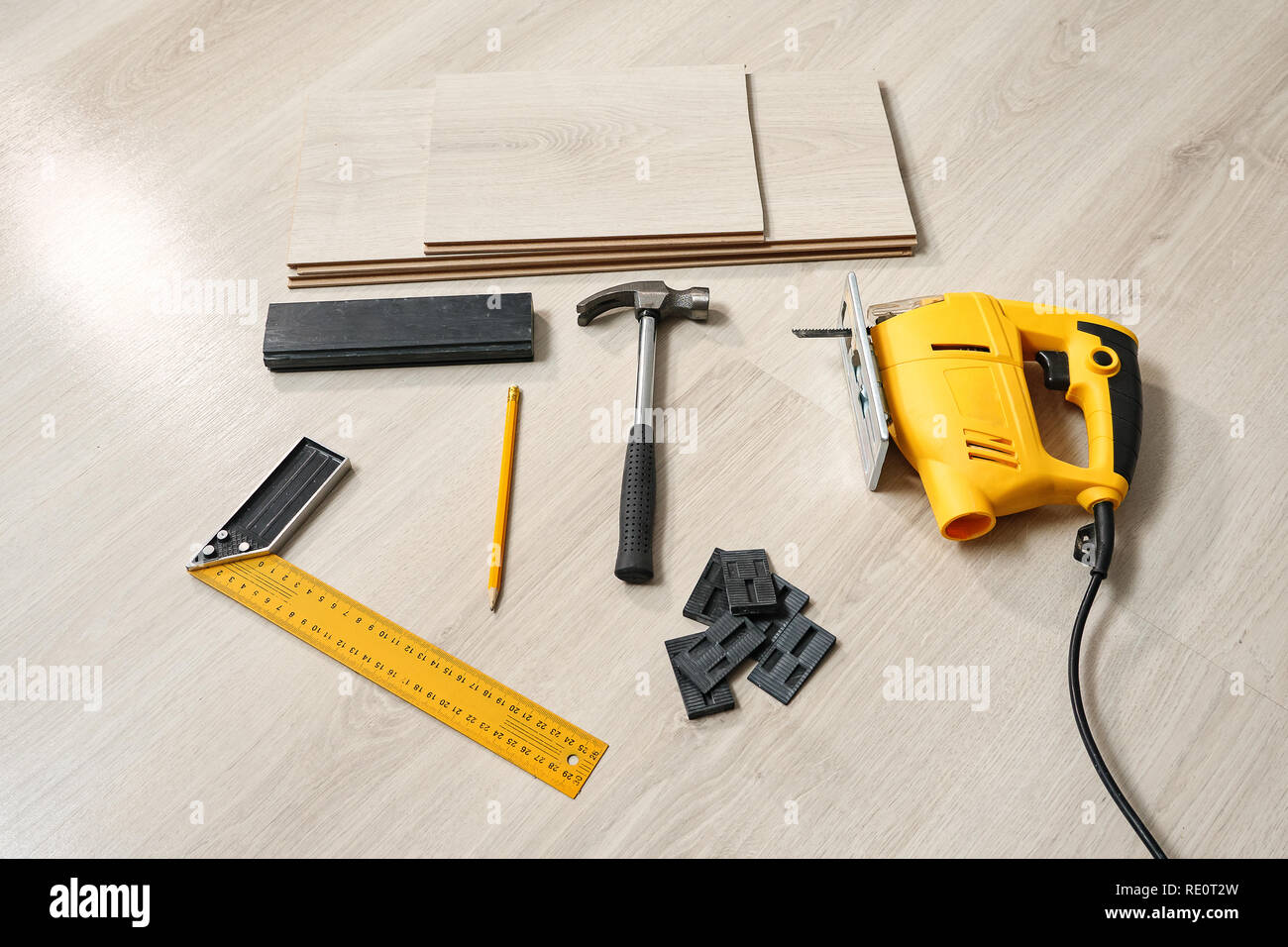 Closeup of wooden plank with hammer and instruments for floor layering ...