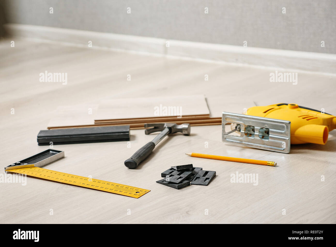 Closeup of wooden plank with hammer and instruments for floor layering ...