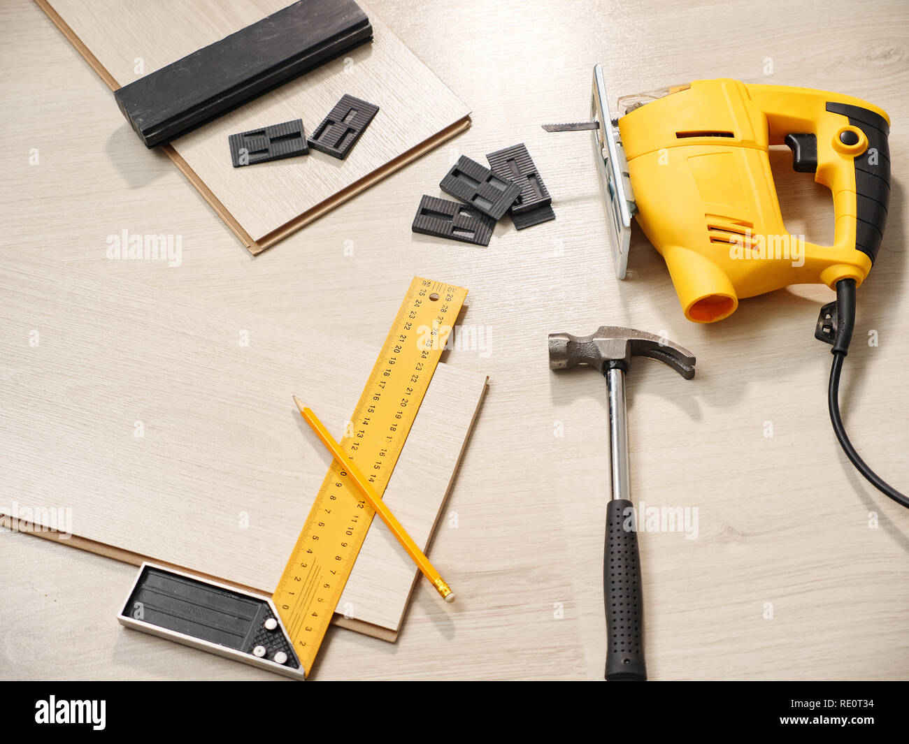 Closeup of wooden plank with hammer and instruments for floor layering ...