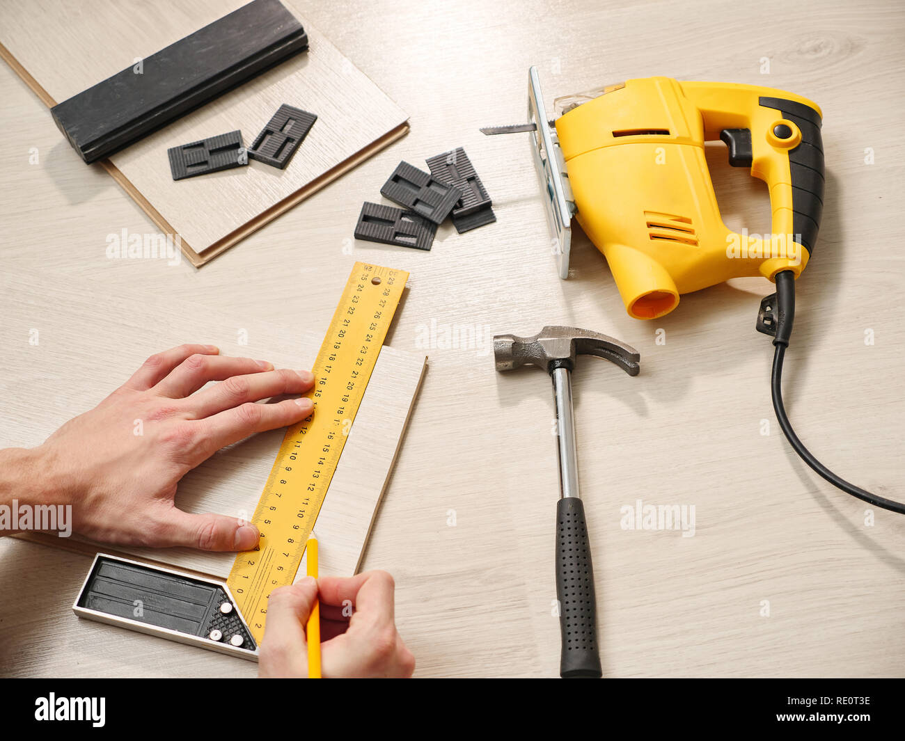 Crop worker measuring plank while making floor layering with ...