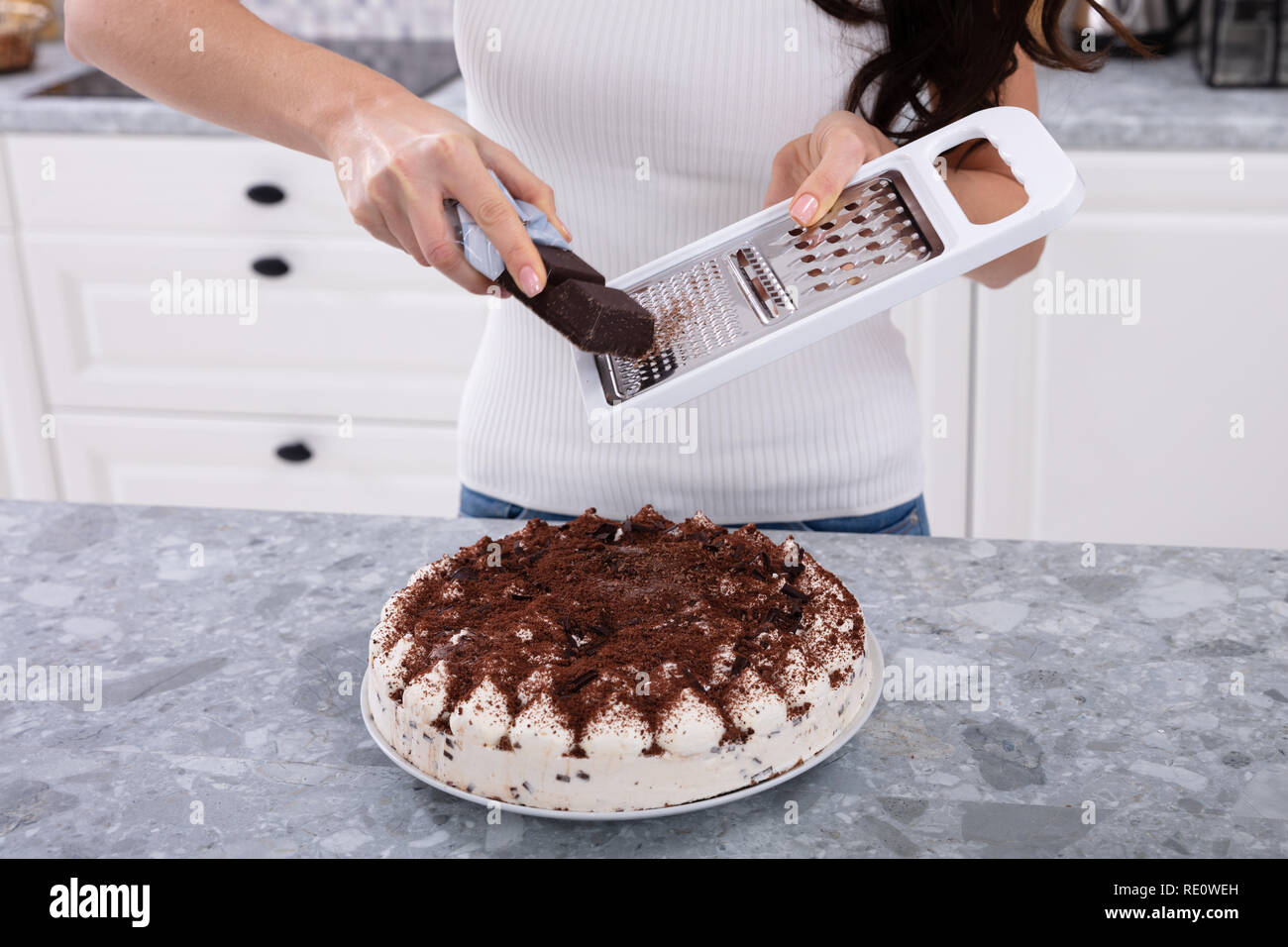 Portrait Of A Smiling Young Woman Grating Chocolate Over Cake Stock ...