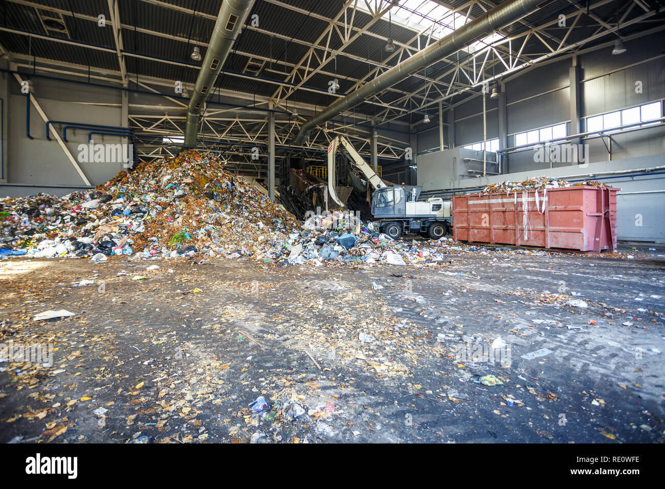 Excavator on primary sorting of garbage at waste processing plant ...