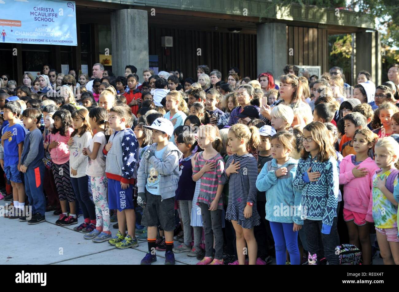 Elementary students recite the Pledge of Allegiance at a flag raising ...