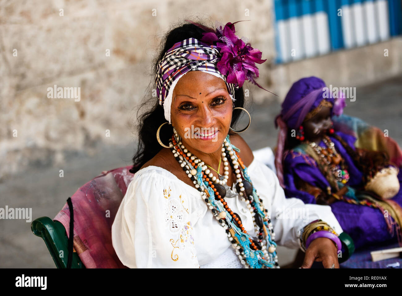 Dark-skinned Cuban in white costume tells fortunes to tourists in ...