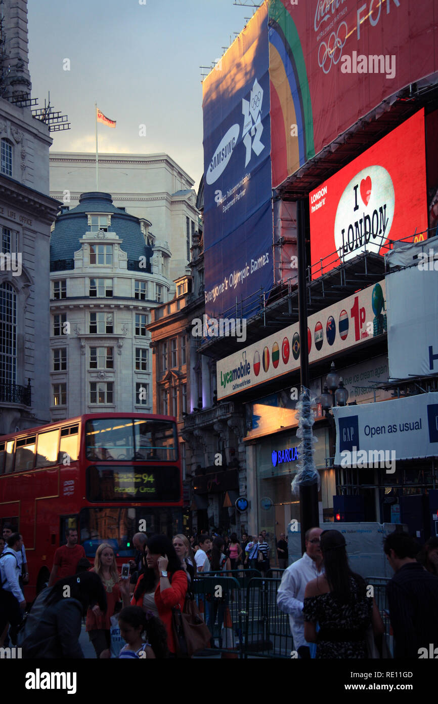 Typical red double-decker bus rushing through Piccadilly Circus. The ...
