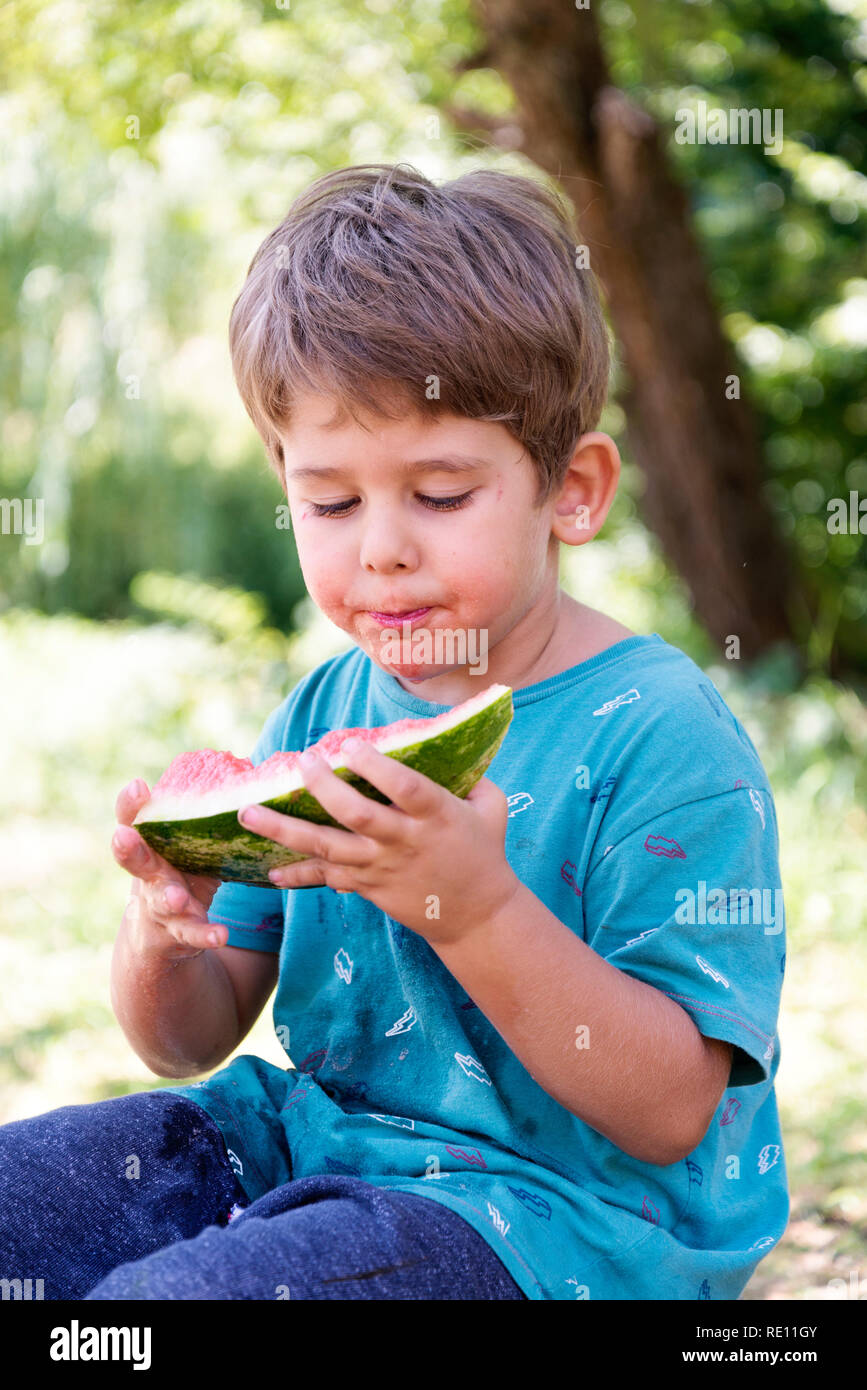 healthy eating concept, boy eating watermelon outdoors, vitamins and ...