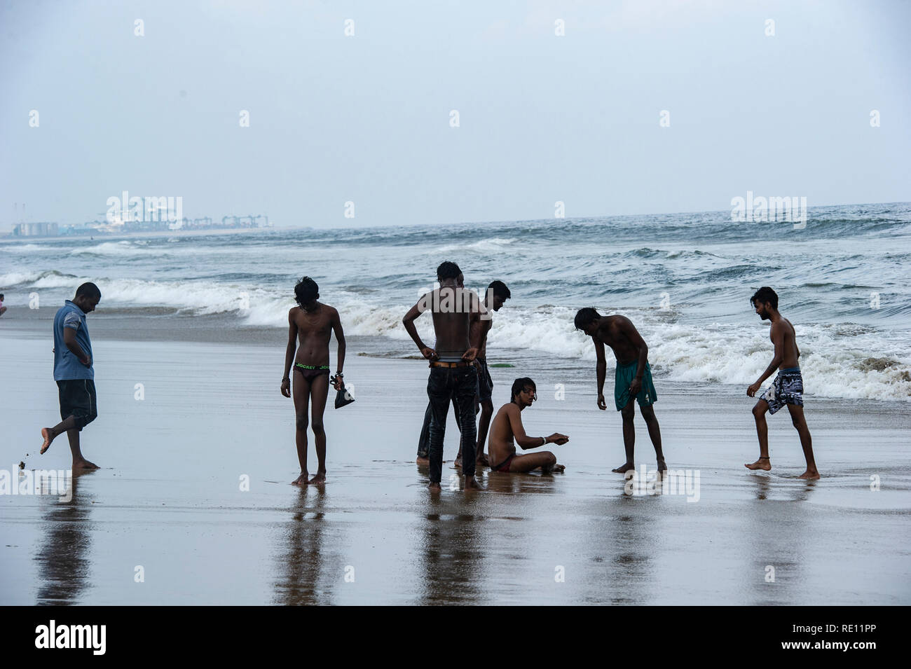 Indian boys swimming in the Bay of Bengal, India, with an Indistrical ...