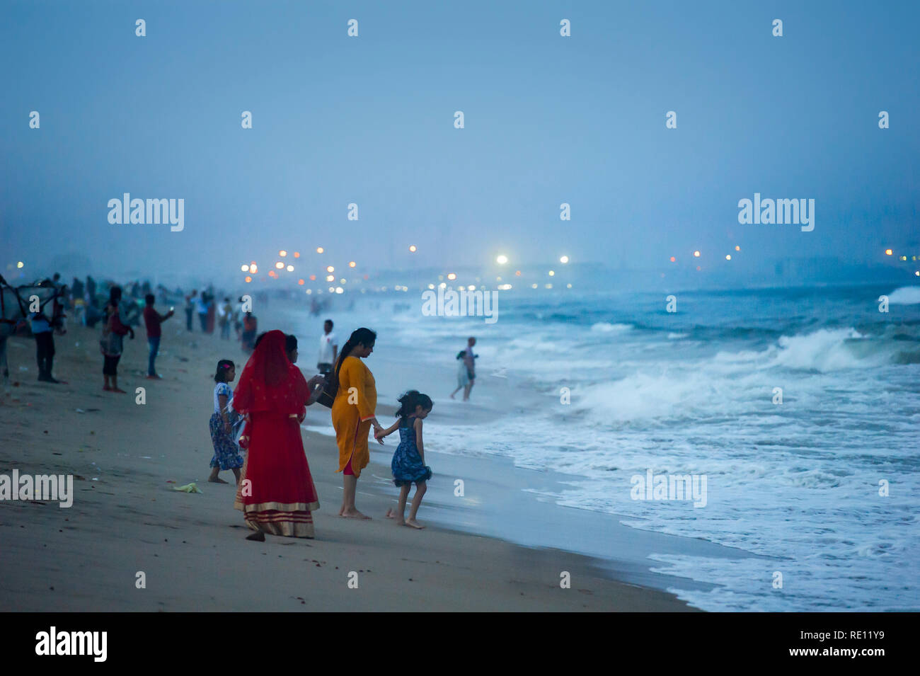 Crowds of people enjoy the last of the light on Marina Beach in Chennai ...