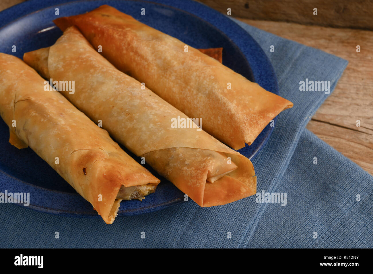 stuffed filo or yufka dough rolls with a spicy meat filling on a blue ...