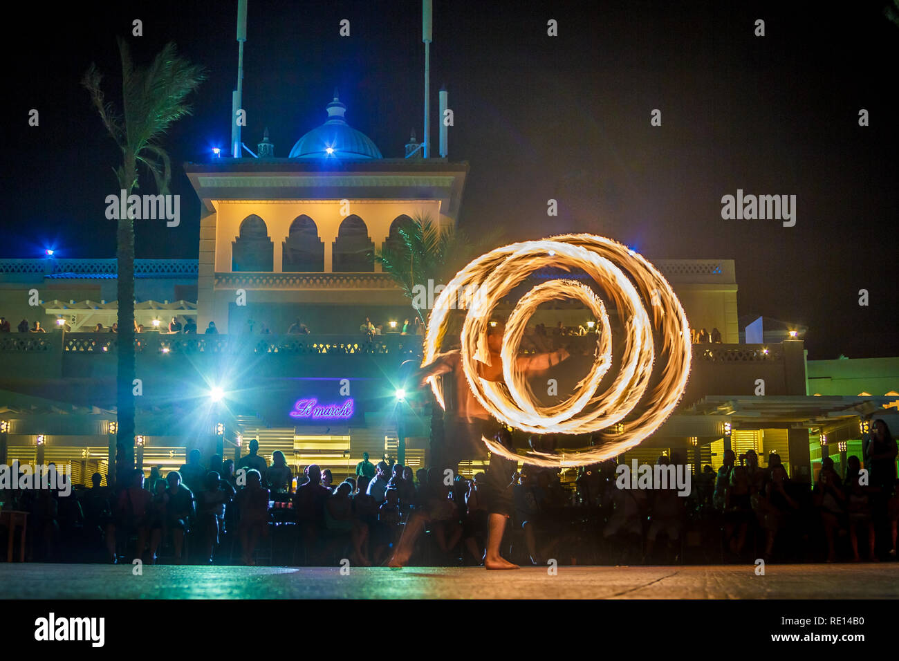 Night performance fire show in front of a crowd of people on the street ...