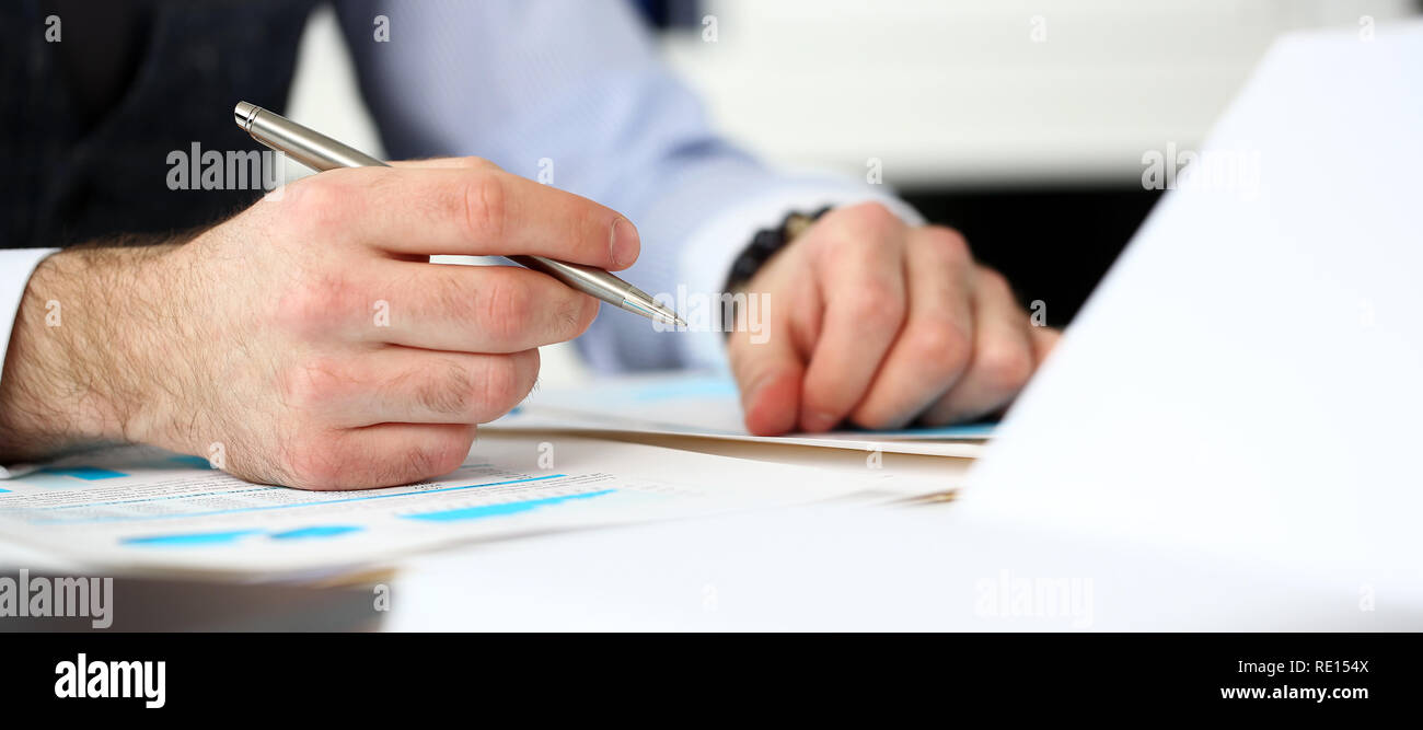 Clerk man at office workplace with silver pen in arms Stock Photo - Alamy