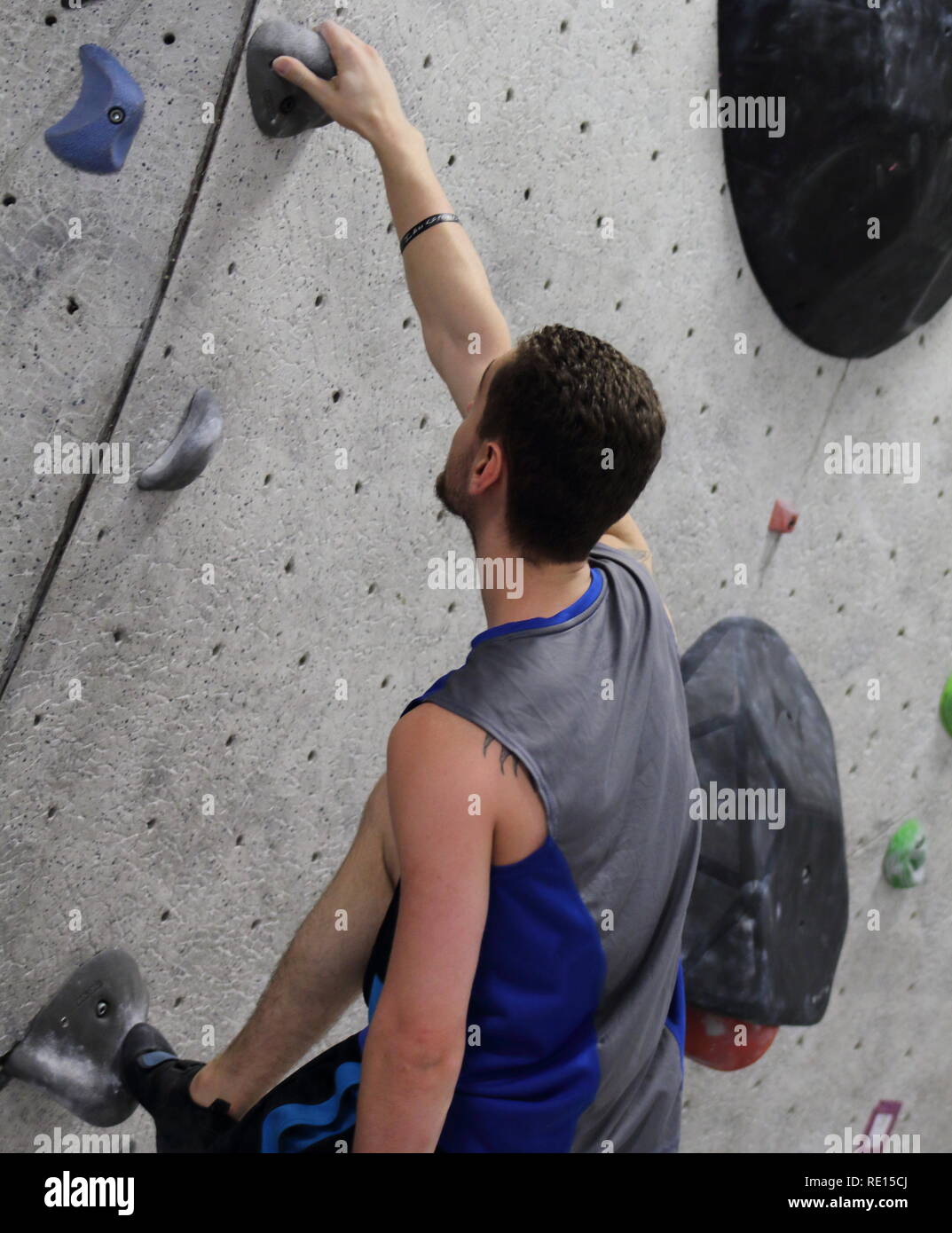 Climber with two limbs holding on to wall Stock Photo - Alamy