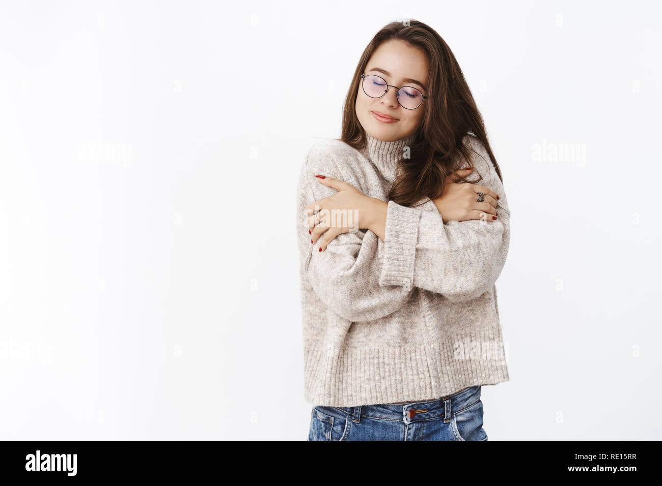 Girl feeling great in soft cozy sweater during chilly weather hugging ...