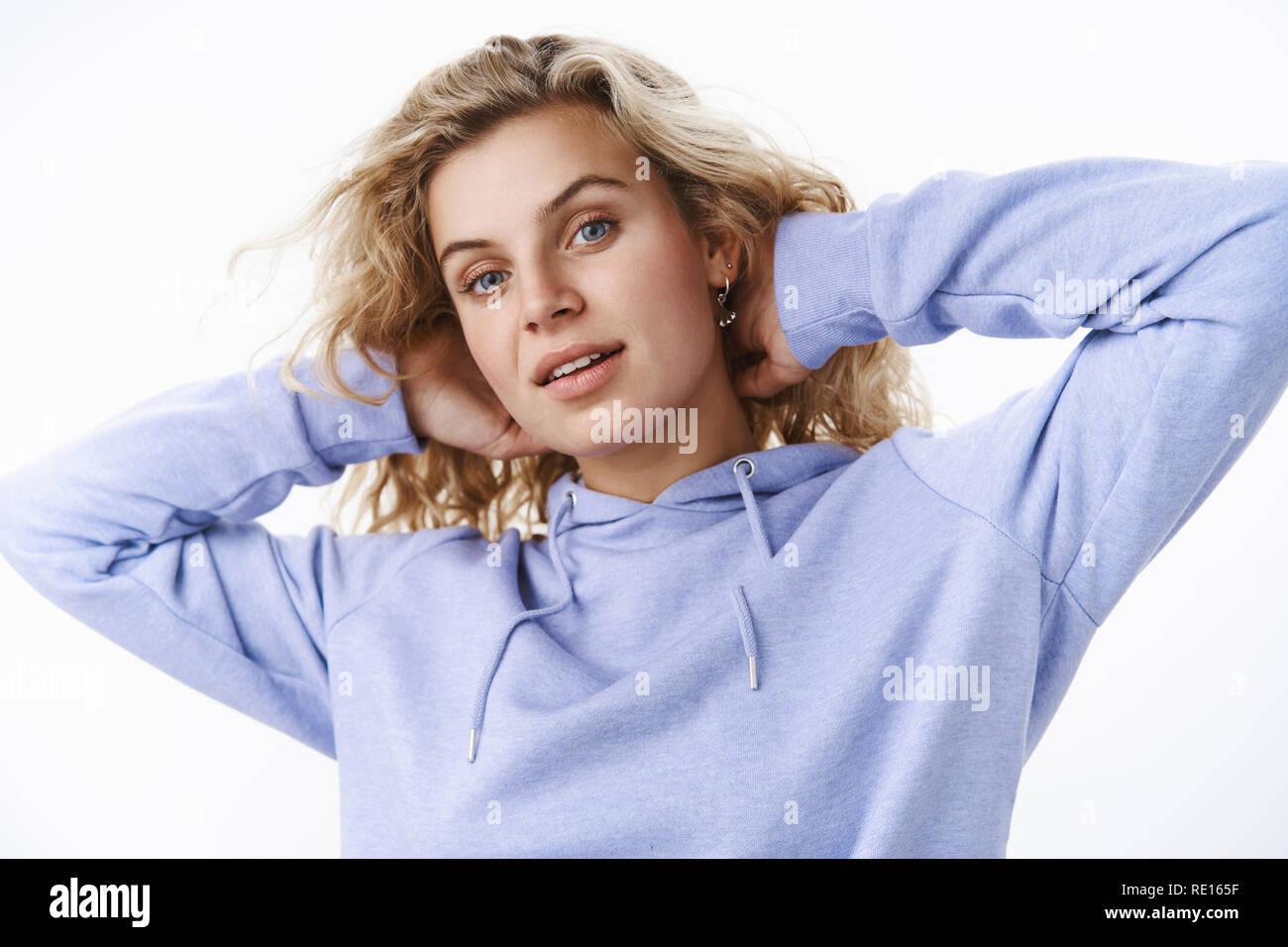 Gir checking haircut, combing hair or stretching with hands behind neck ...