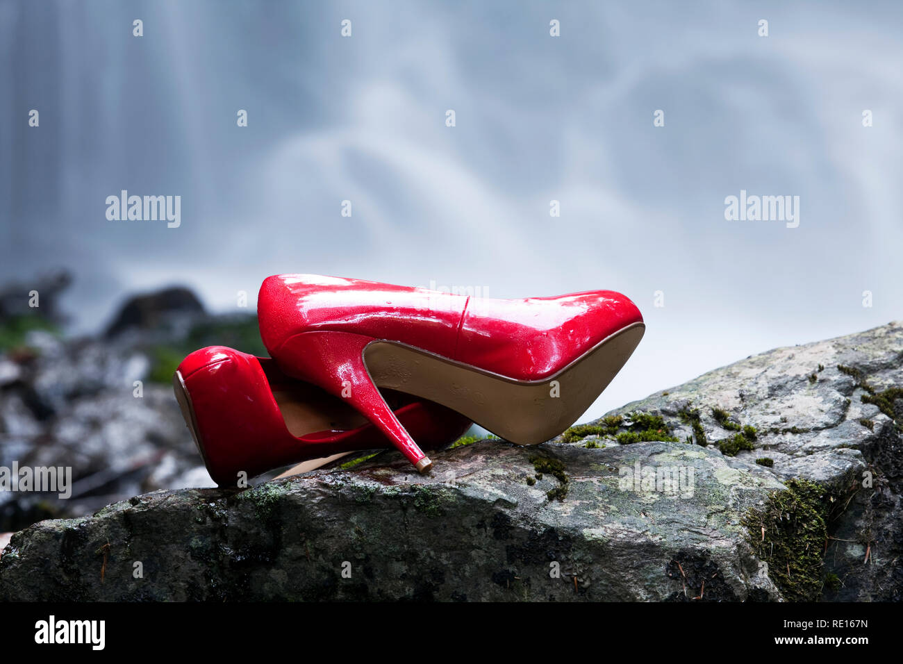 red women's shoes in front of a waterfall Stock Photo - Alamy