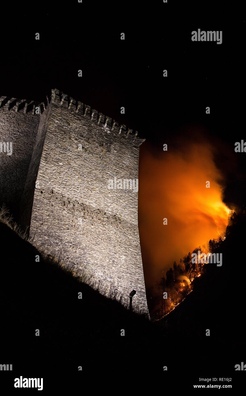The old medieval castle of Mesocco and forest on fire Stock Photo - Alamy