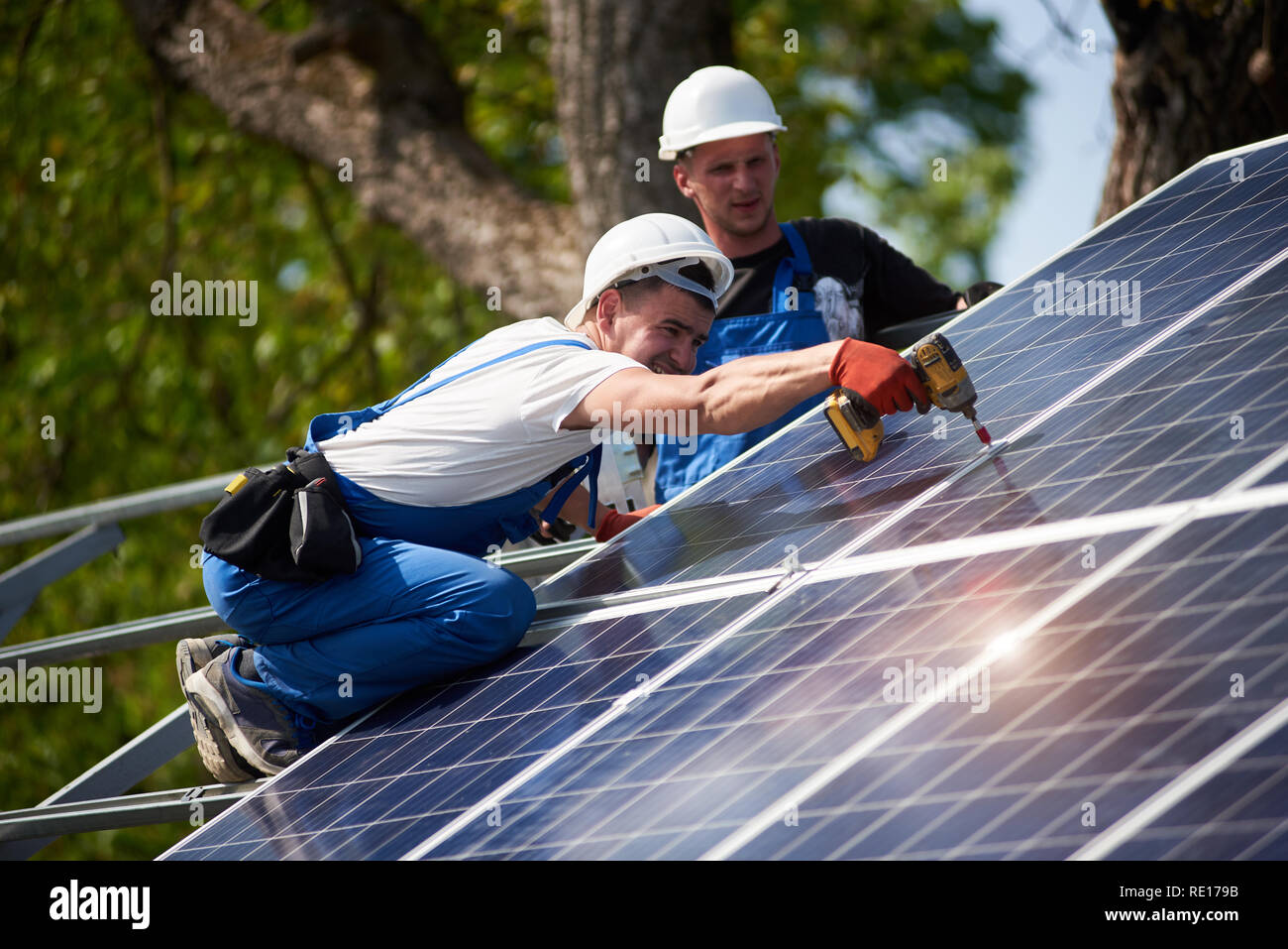Professional technicians working with electrical screwdriver installing ...