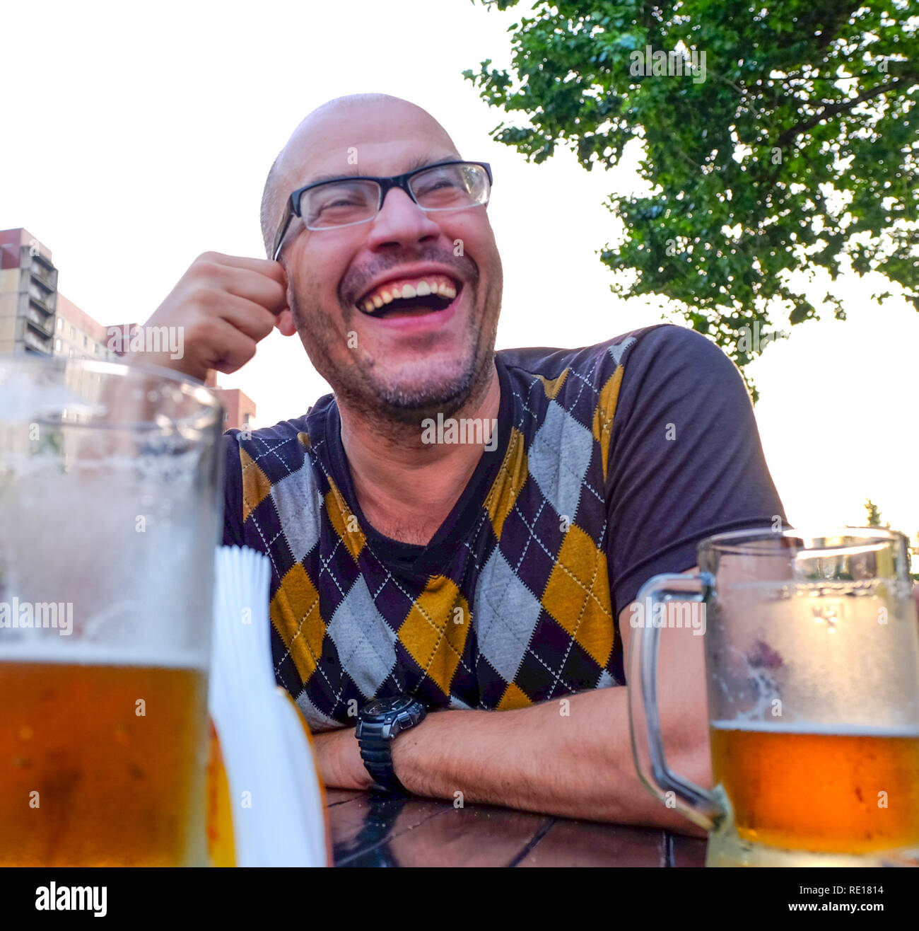 The man drinking cider jokes, smiles. A young man drinks cider in an ...