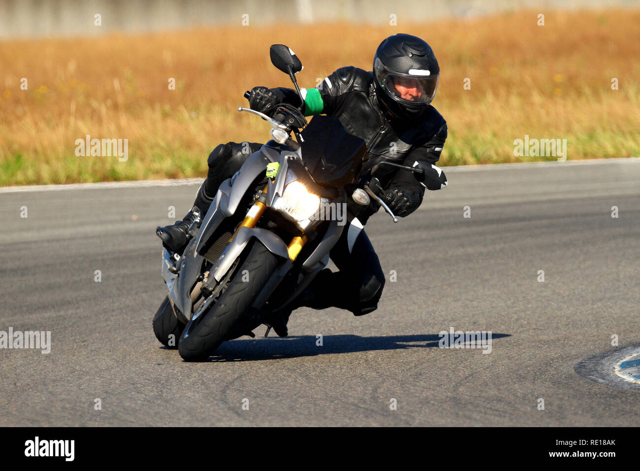 A man leaning over his bike in a curve on a circuit Stock Photo - Alamy