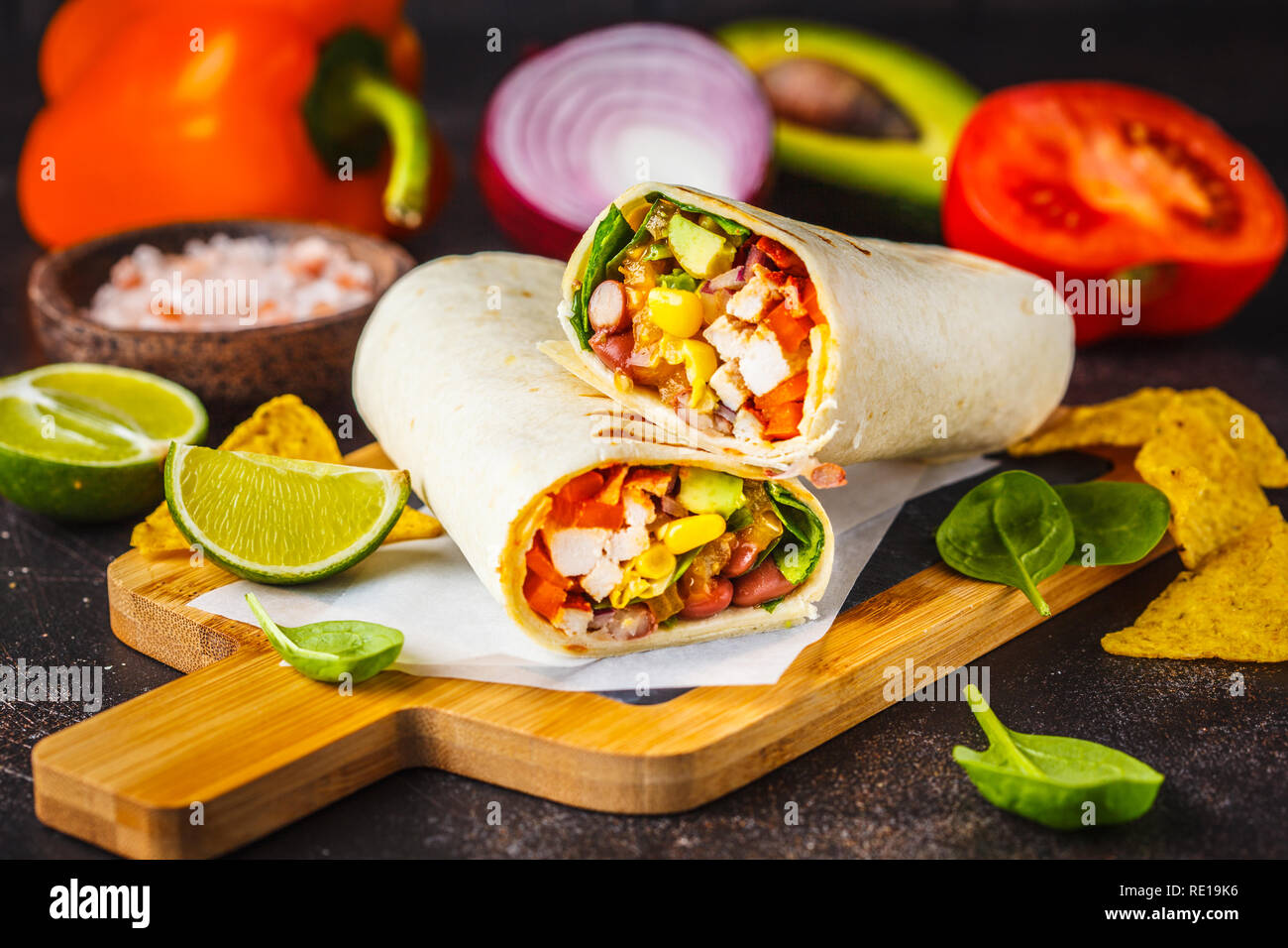 Grilled burritos wraps with chicken, beans, corn, tomatoes and avocado ...