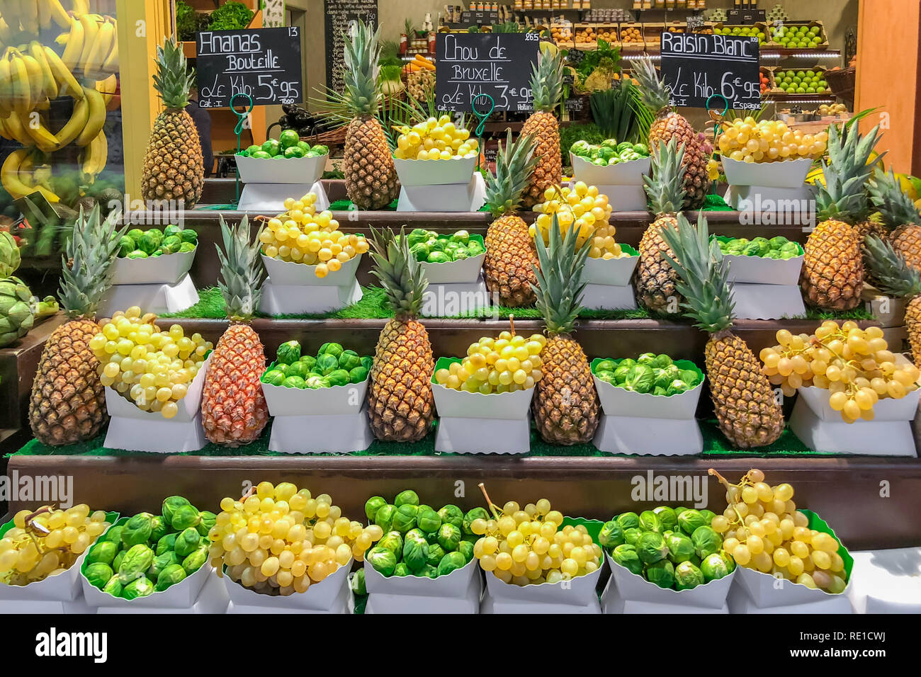 Fresh grapes pineapples and Brussels sprouts on the grocery store in ...