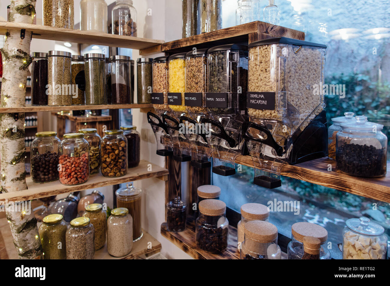 Organic shop interior. Display of glass jars on shelves filled with ...