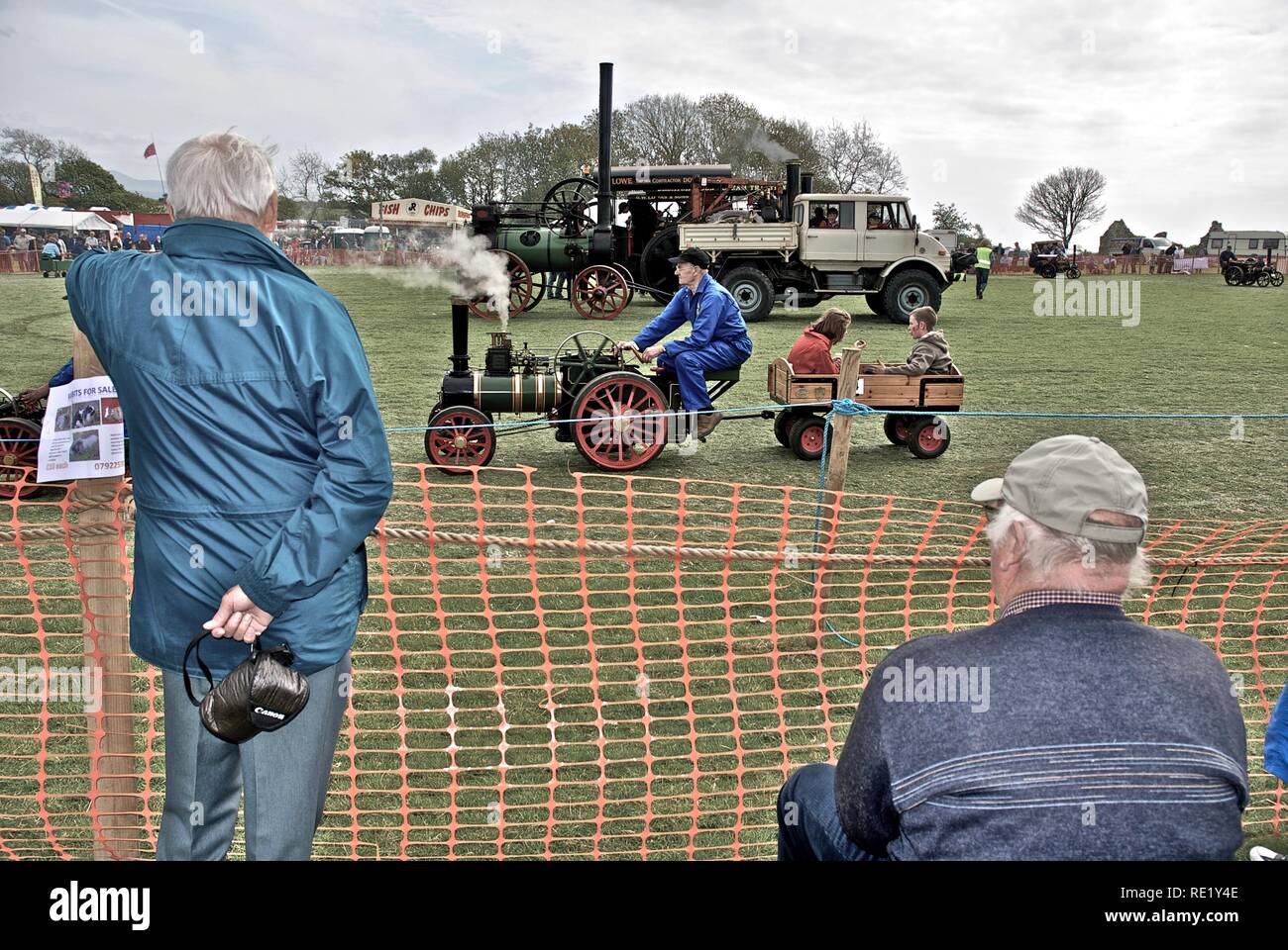 Old enthusiasts enjoy watching a miniature steam traction engine at the ...