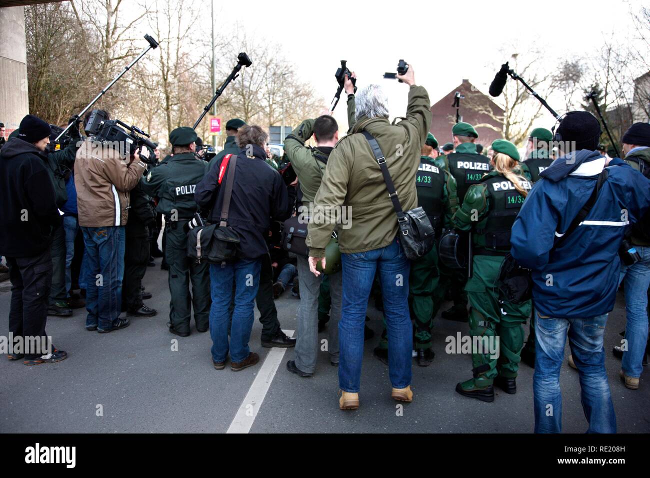 Media representatives watch and film the clearing of a road blockade ...