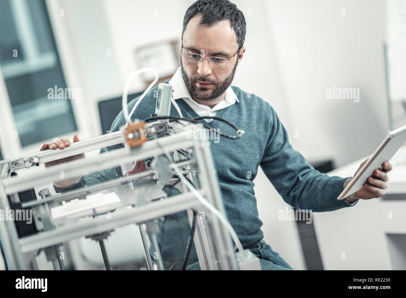 Serious professional adult engineer testing 3d printer Stock Photo - Alamy