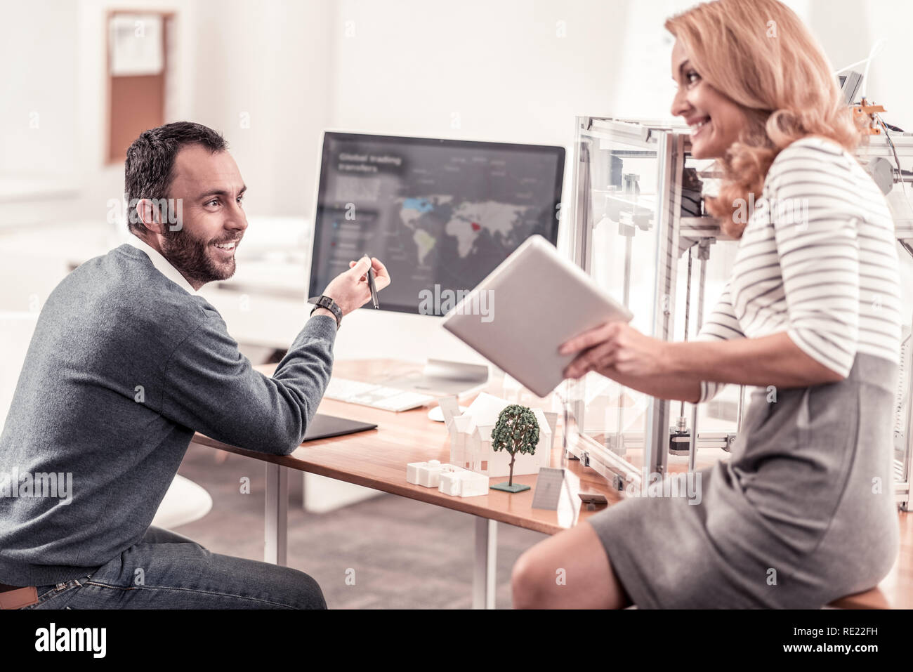 Smart smiling colleagues discussing their new idea Stock Photo - Alamy