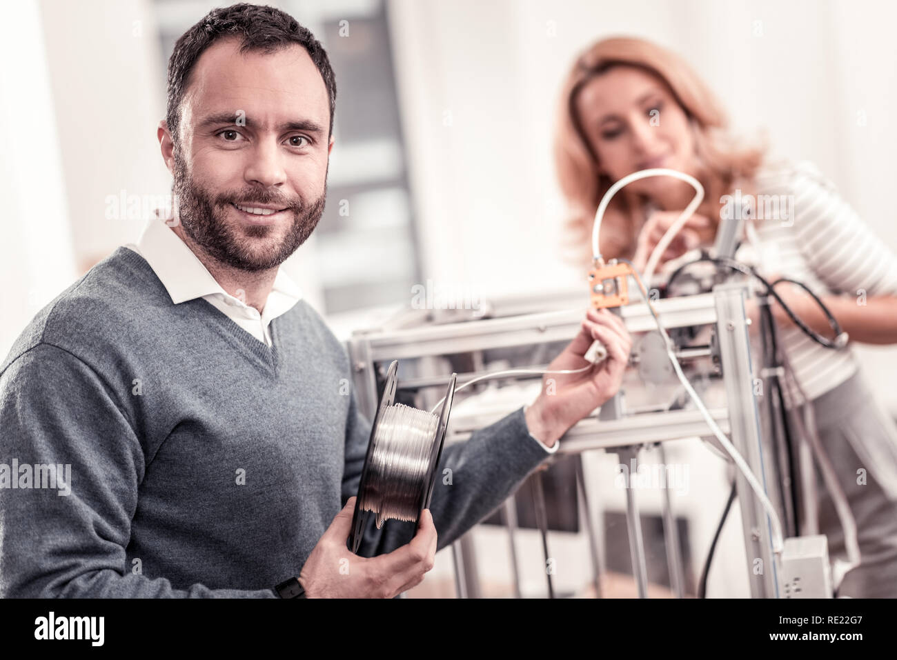 Bearded engineer holding a coil of wire Stock Photo - Alamy