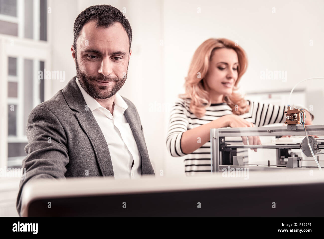 Pleasant man and woman creating new design project Stock Photo - Alamy