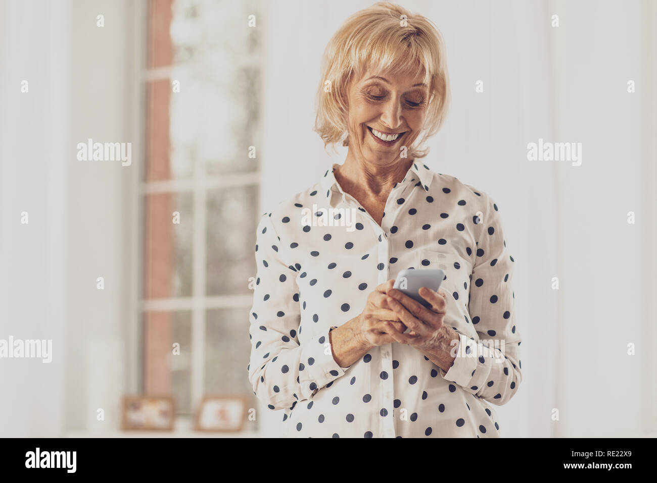 Joyful housewife typing friendly message Stock Photo - Alamy