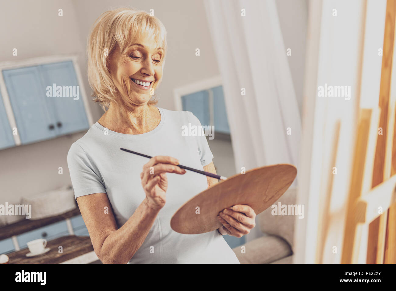 Cheerful female person mixing colors Stock Photo - Alamy