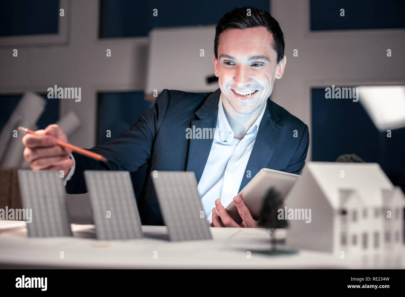 Happy positive man looking at the solar battery models Stock Photo - Alamy