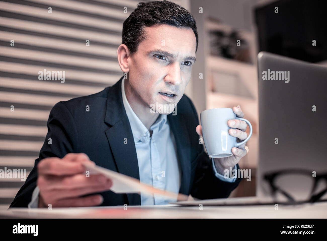 Serious nice man looking at the computer screen Stock Photo - Alamy