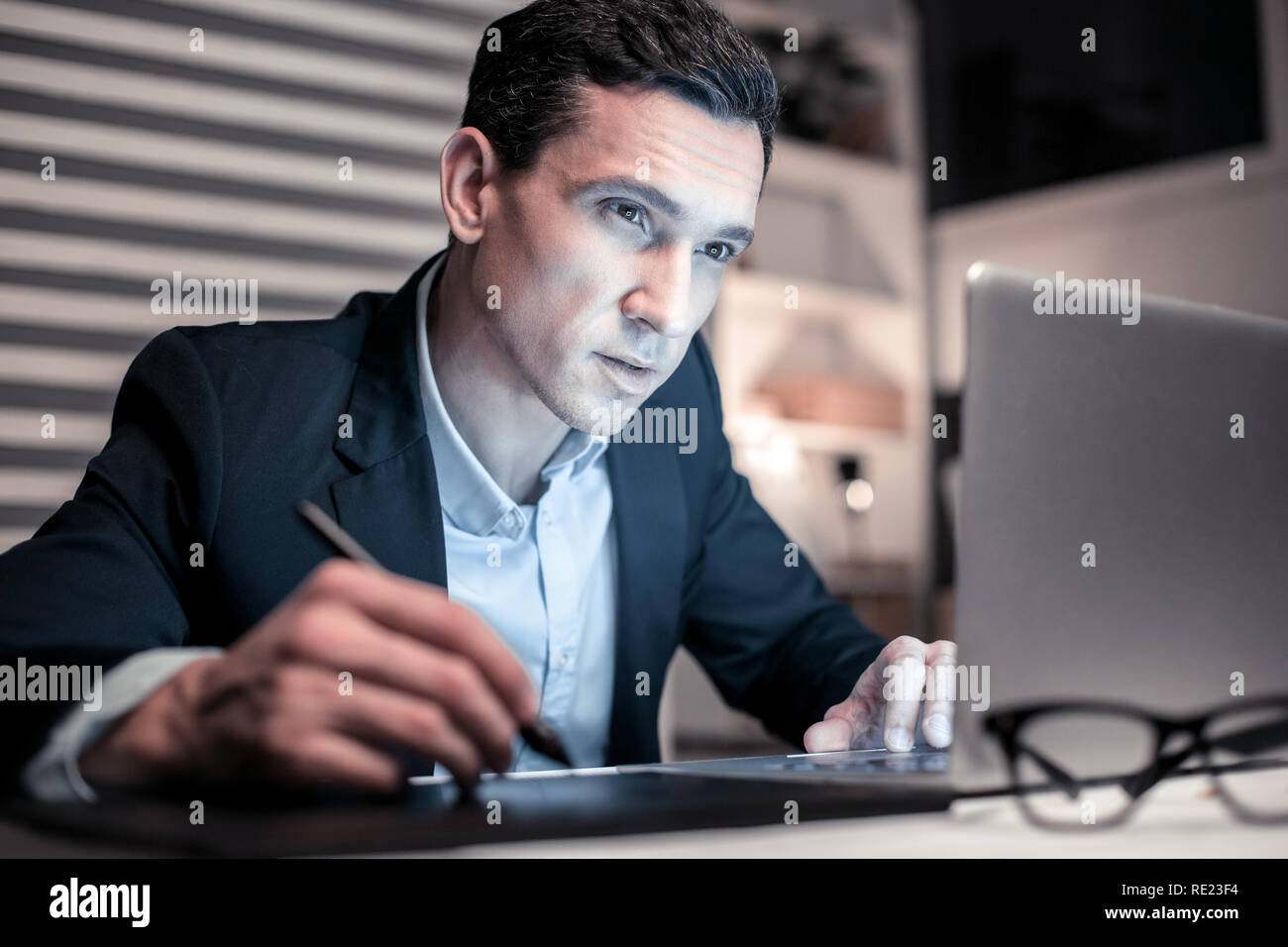 Professional smart man taking notes while working Stock Photo - Alamy