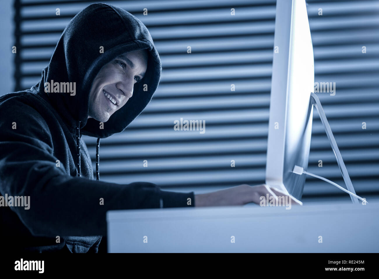 Smart professional joyful hacker committing cyber crime Stock Photo - Alamy