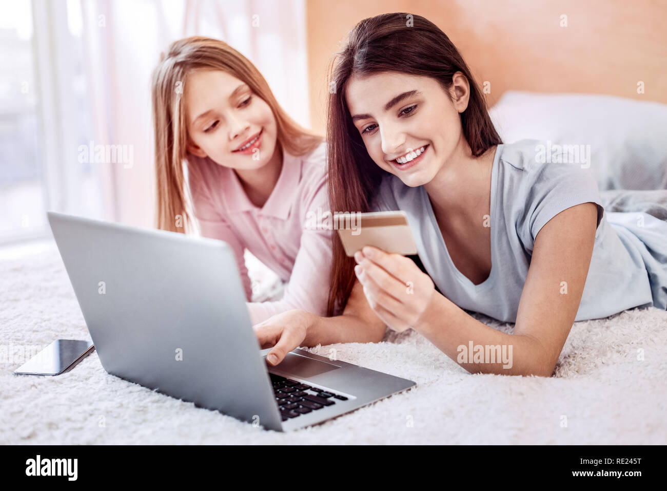 Jolly two girls shopping online at home Stock Photo - Alamy